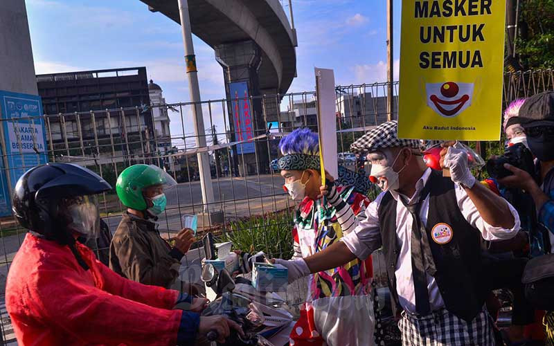 Aksi Badut Bagi-Bagi Masker ke Pengguna Jalan di Jakarta
