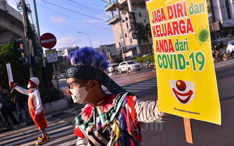 Aksi Badut Bagi-Bagi Masker ke Pengguna Jalan di Jakarta