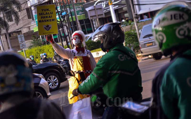 Aksi Badut Bagi-Bagi Masker ke Pengguna Jalan di Jakarta