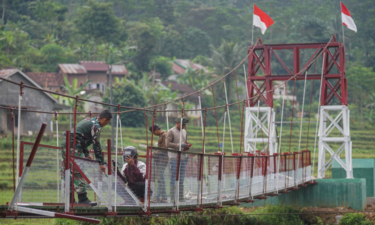 Anggota TNI Bersama Warga Bangun Jembatan Merah Putih